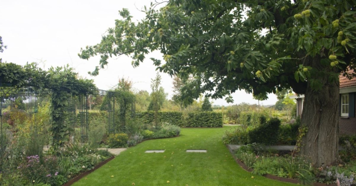 Glooiend cortenstaal scheidt border en gazon bij landelijk gelegen ...